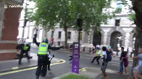 Riot police chase down protester at anti-vaccine protest in London ...